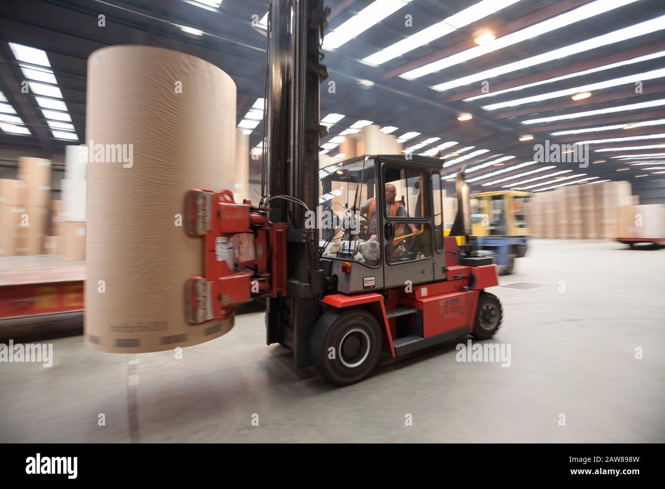 red forklift lifting a new paper roll in a paper warehouse Stock Photo ...