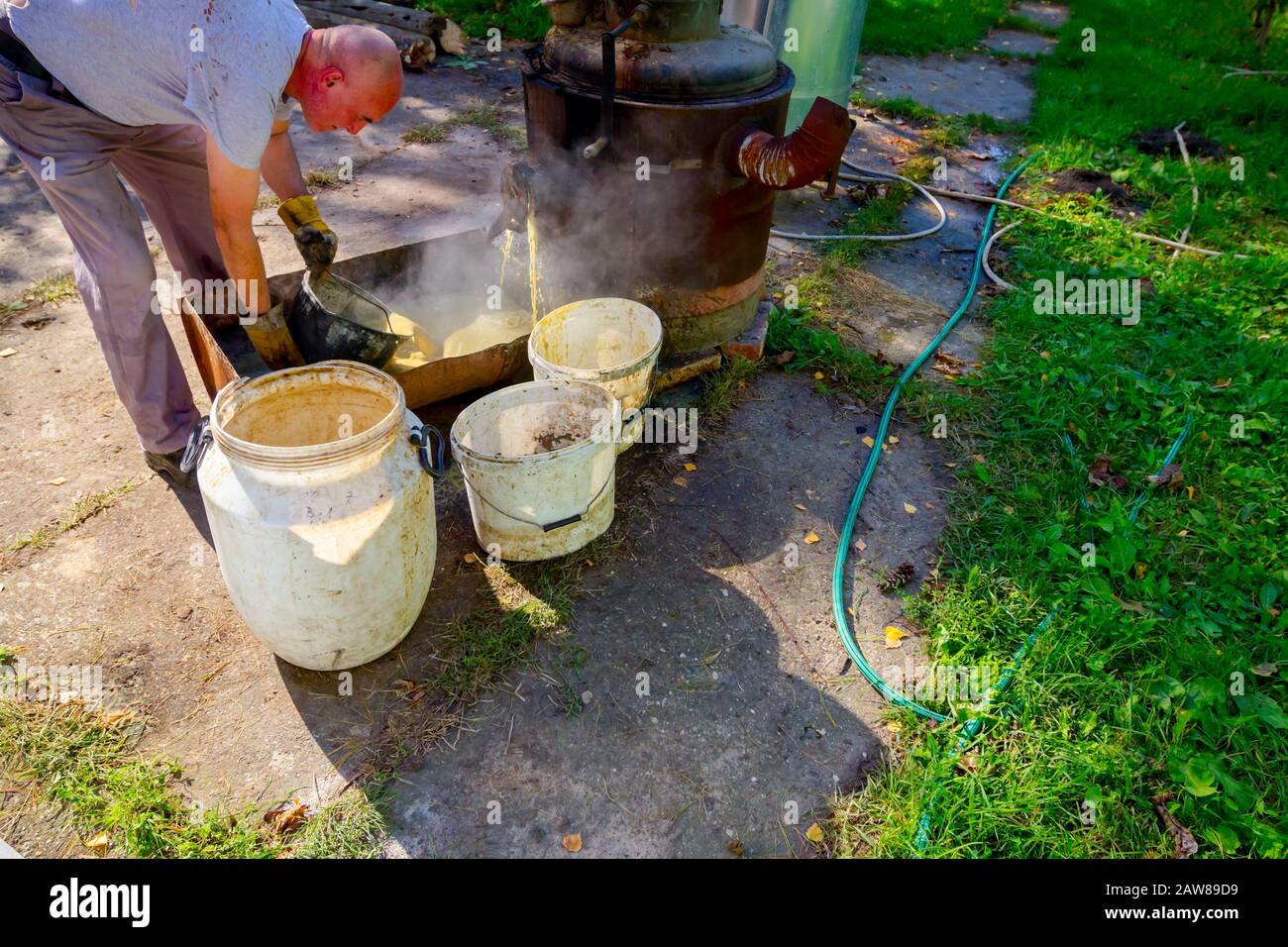 Man is unloading boiler of homemade distillery made of copper to ...