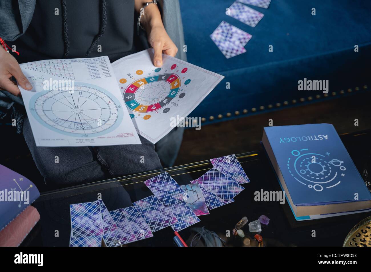 Astrologer with birth charts sitting at the table Stock Photo - Alamy
