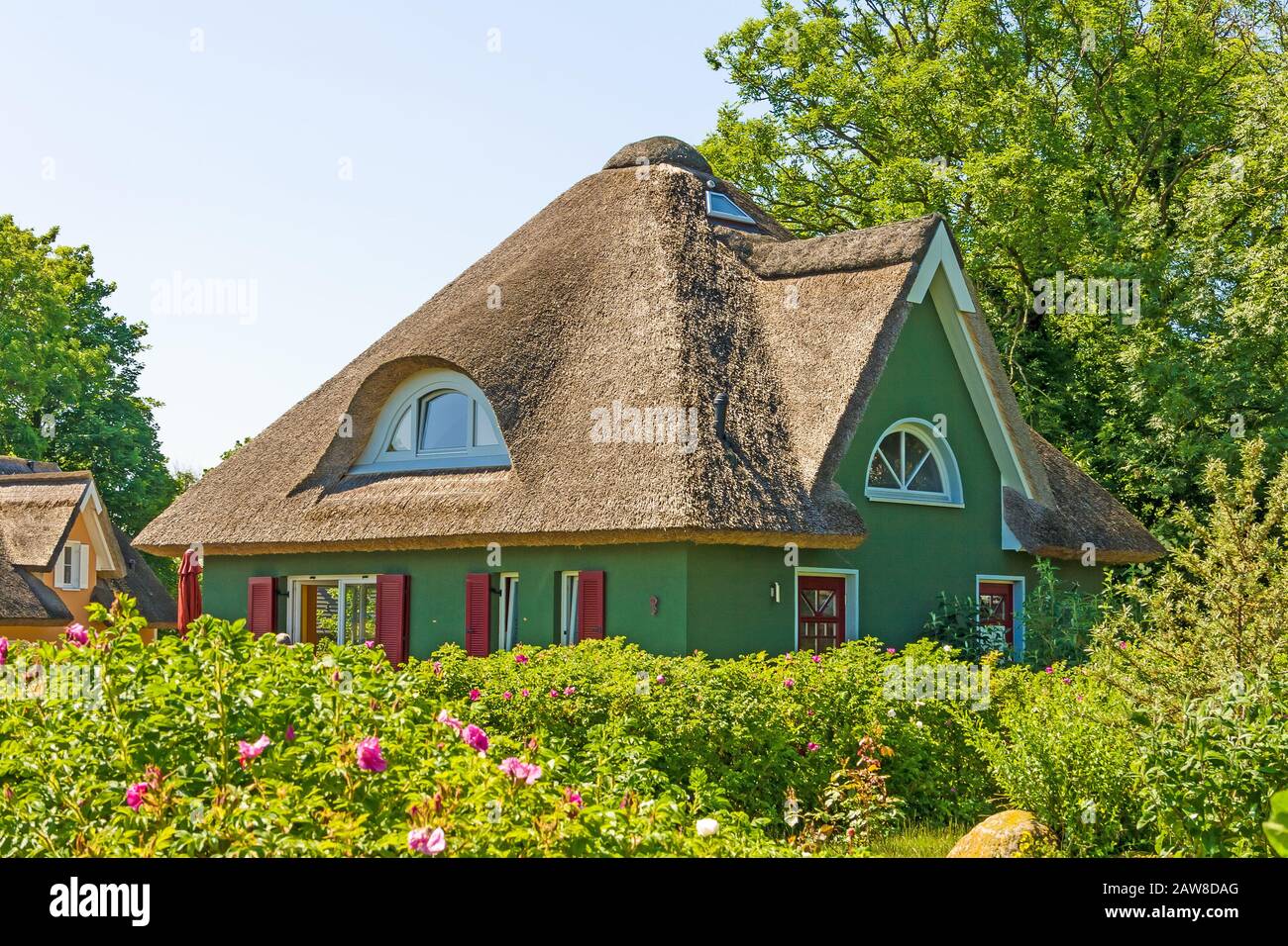 green painted thatched-roof house with garden Stock Photo - Alamy