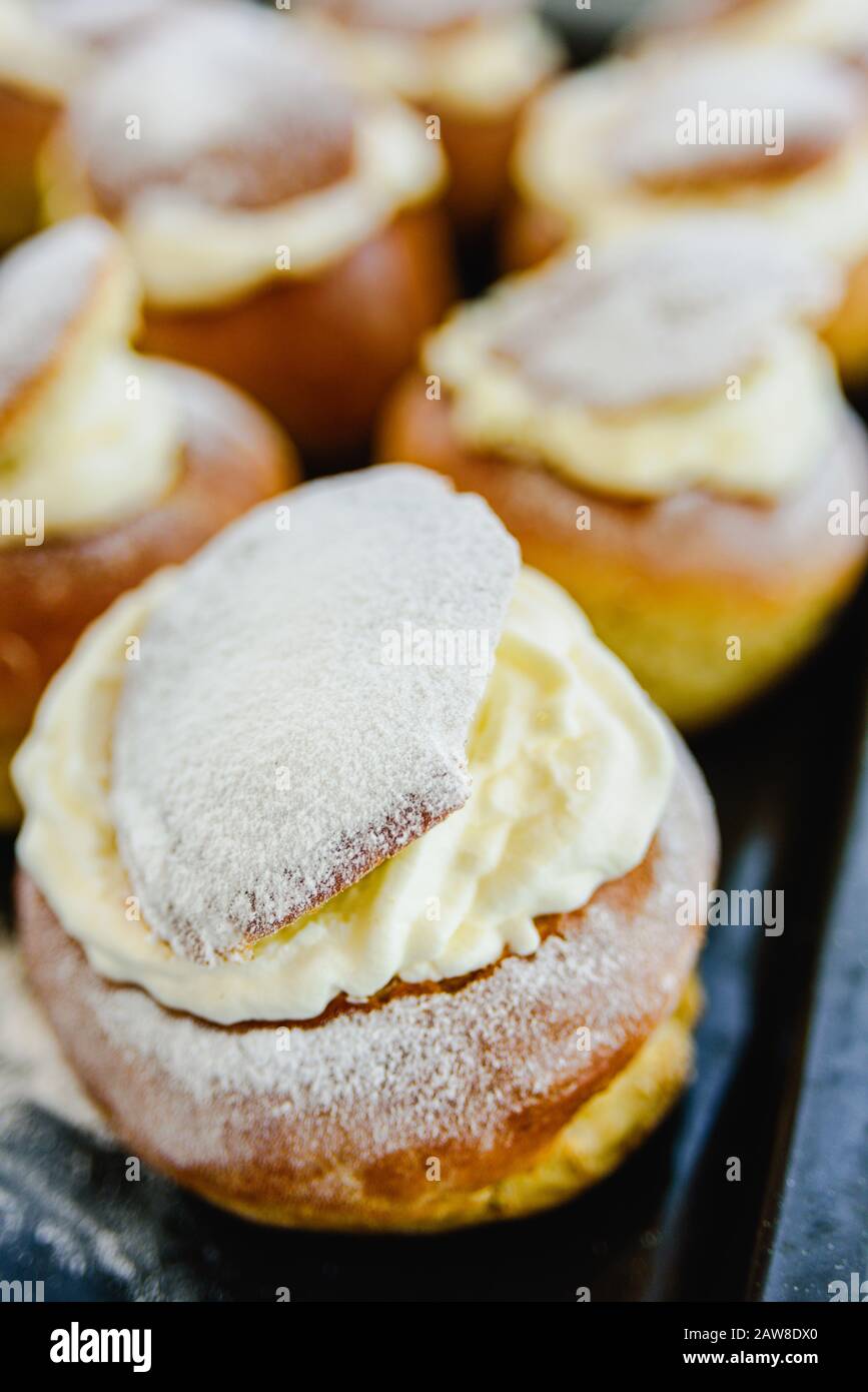 Semla swedish whipped cream filled bun on oven tray and grey concrete ...