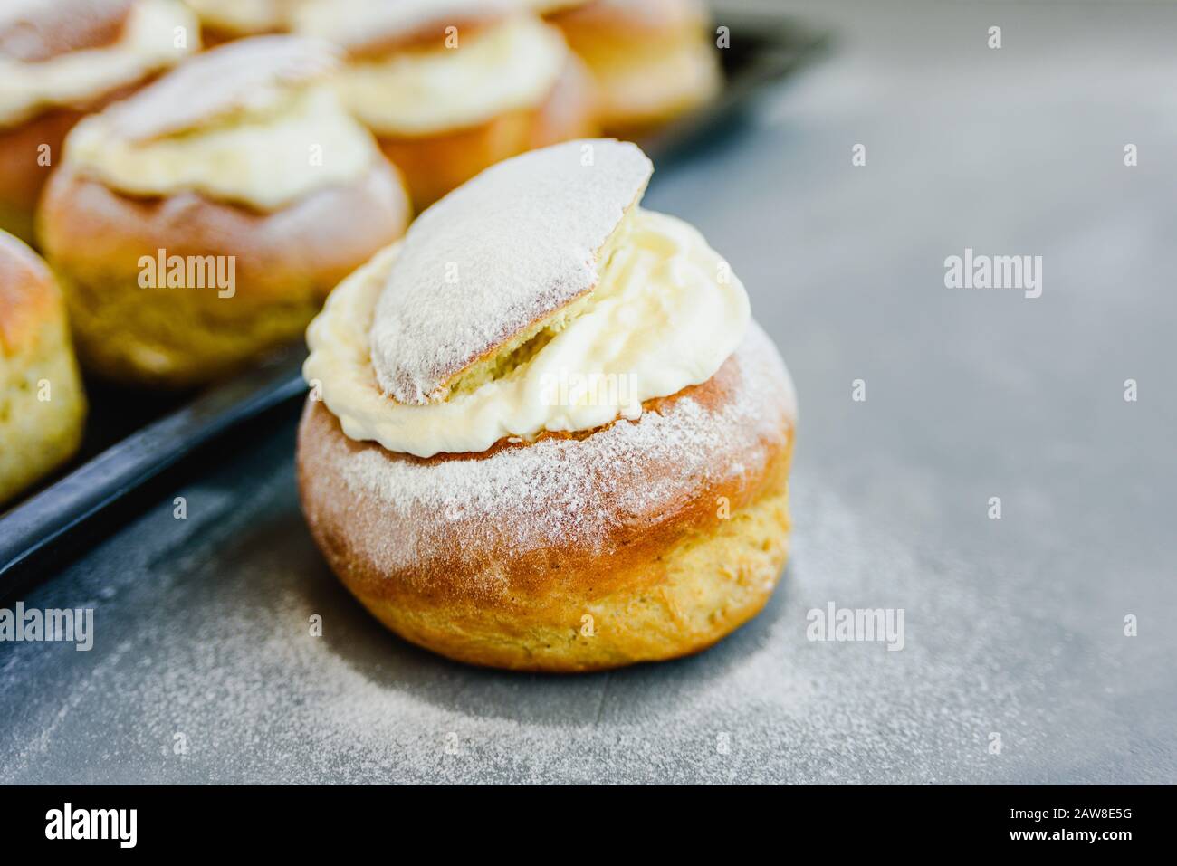 Semla swedish whipped cream filled bun on oven tray and grey concrete ...