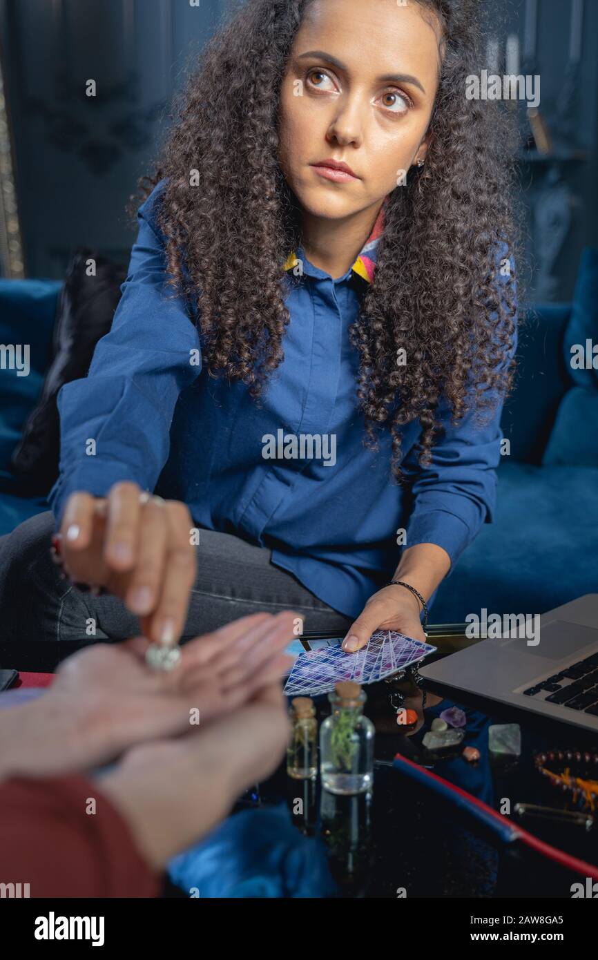 Beautiful soothsayer looking at her female client Stock Photo - Alamy