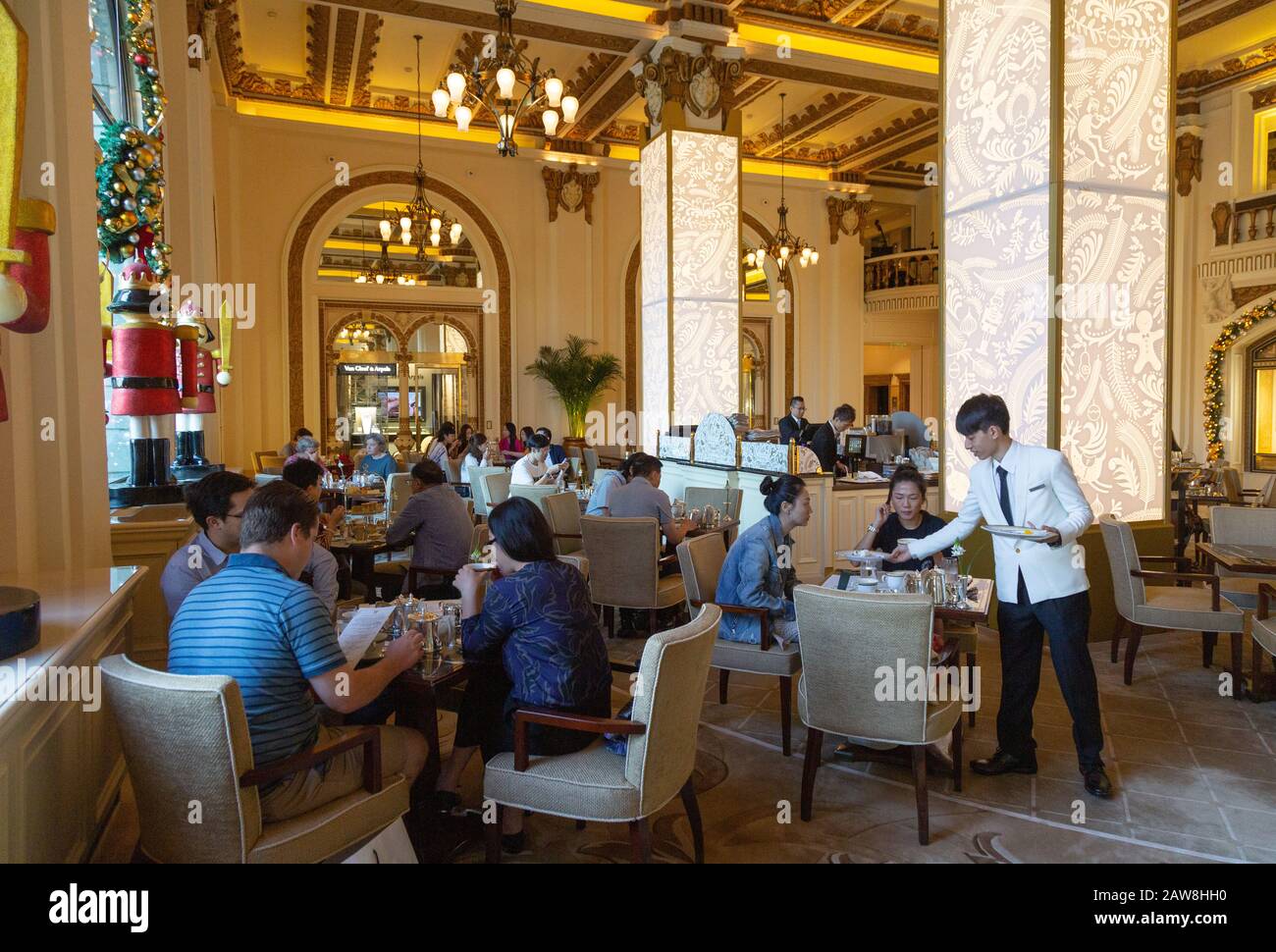 People having afternoon tea in the lobby of the Peninsula Hotel ...