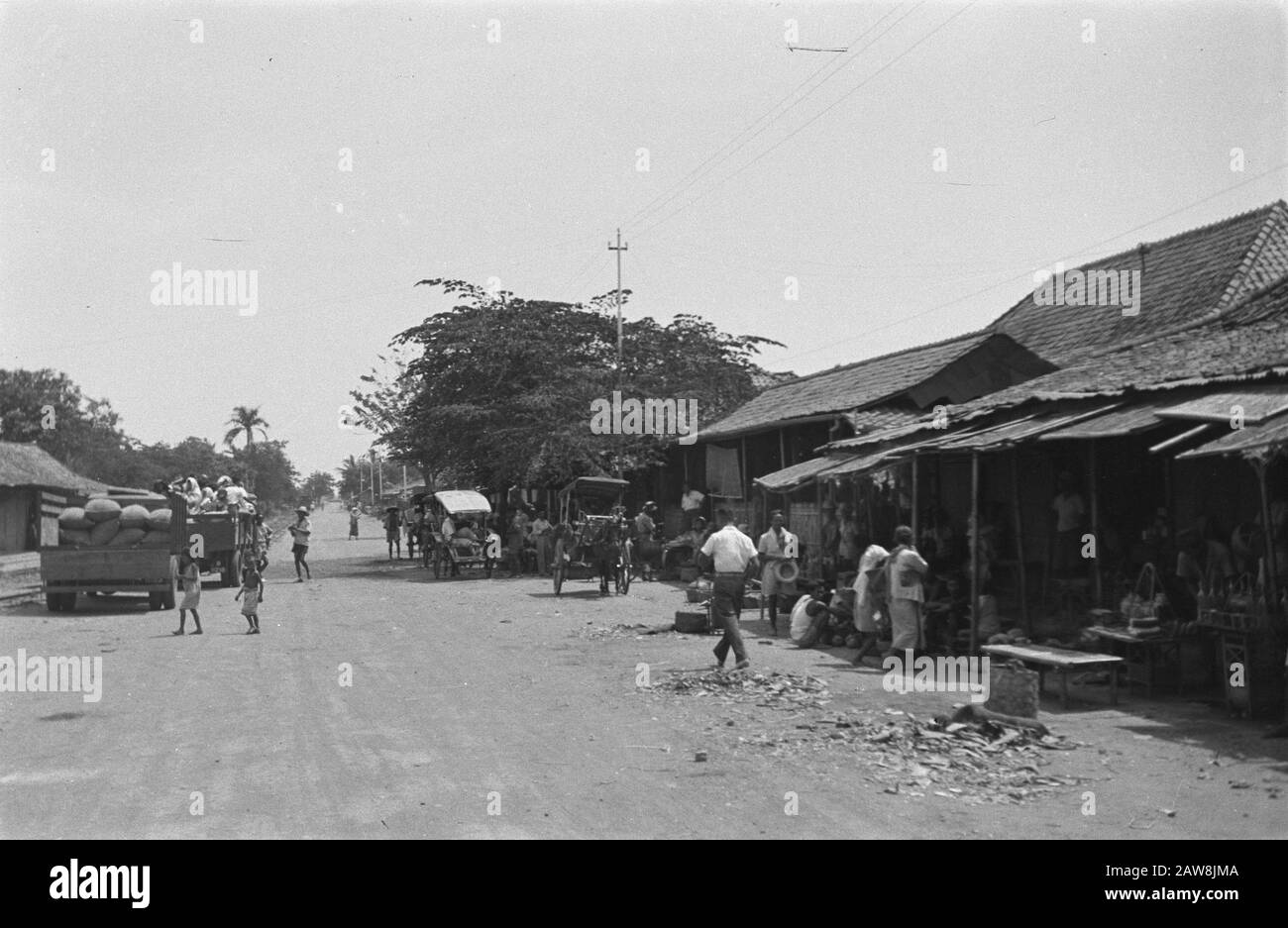 Krawang [Krawang. View of a road with activity. Trucks, dokars and ...