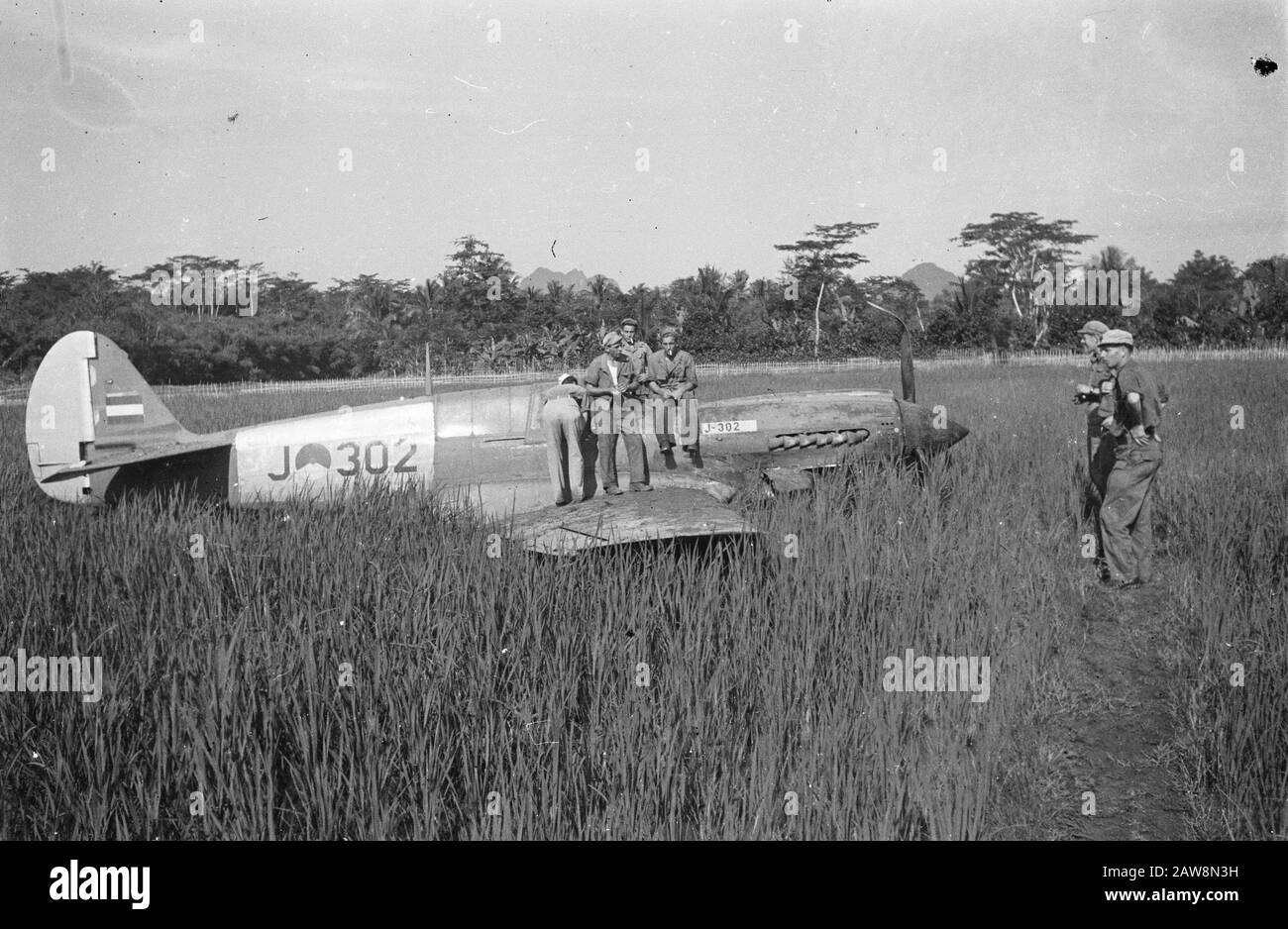 Emergency landing of a Curtiss P40 near Solo [Dutch soldiers sit on a ...