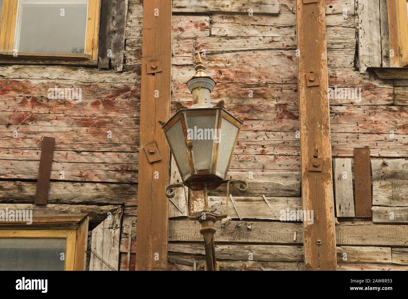 Windows of the old wooden house. wooden plank wall with vintage lamp ...