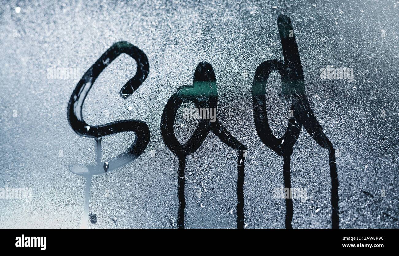 Window with raindrops. Stock photo the inscription "sad" in wet glass ...
