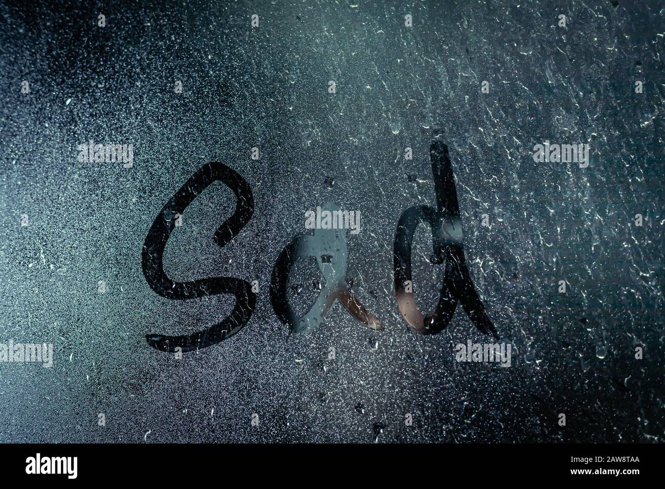 Window with raindrops. Stock photo the inscription "sad" in wet glass ...
