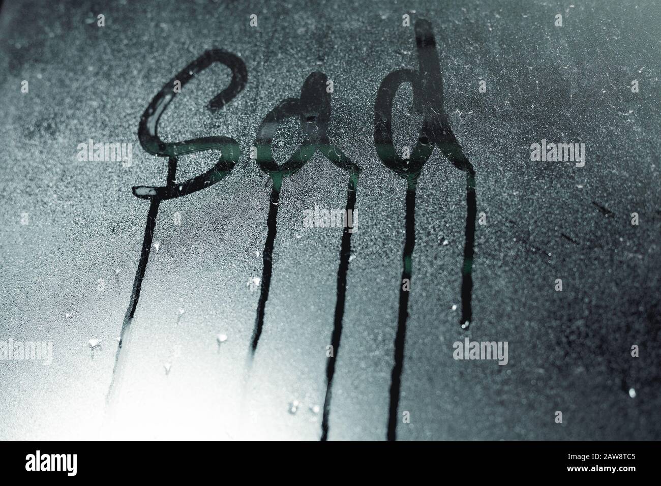 Window with raindrops. Stock photo the inscription "sad" in wet glass ...