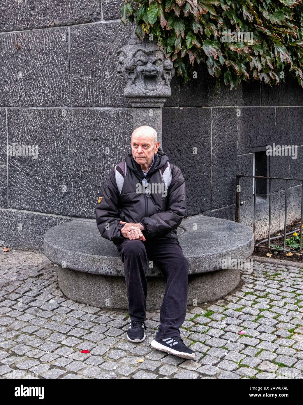 Elderly tourist sitting on stone bench hi-res stock photography and ...