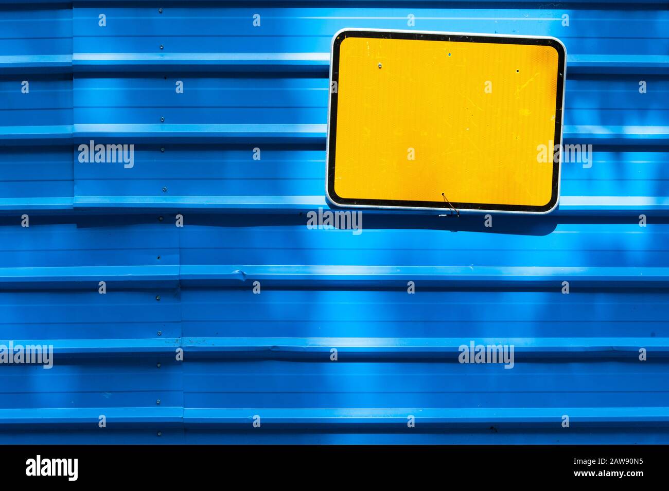 blank yellow sign on blue aluminium background Stock Photo - Alamy