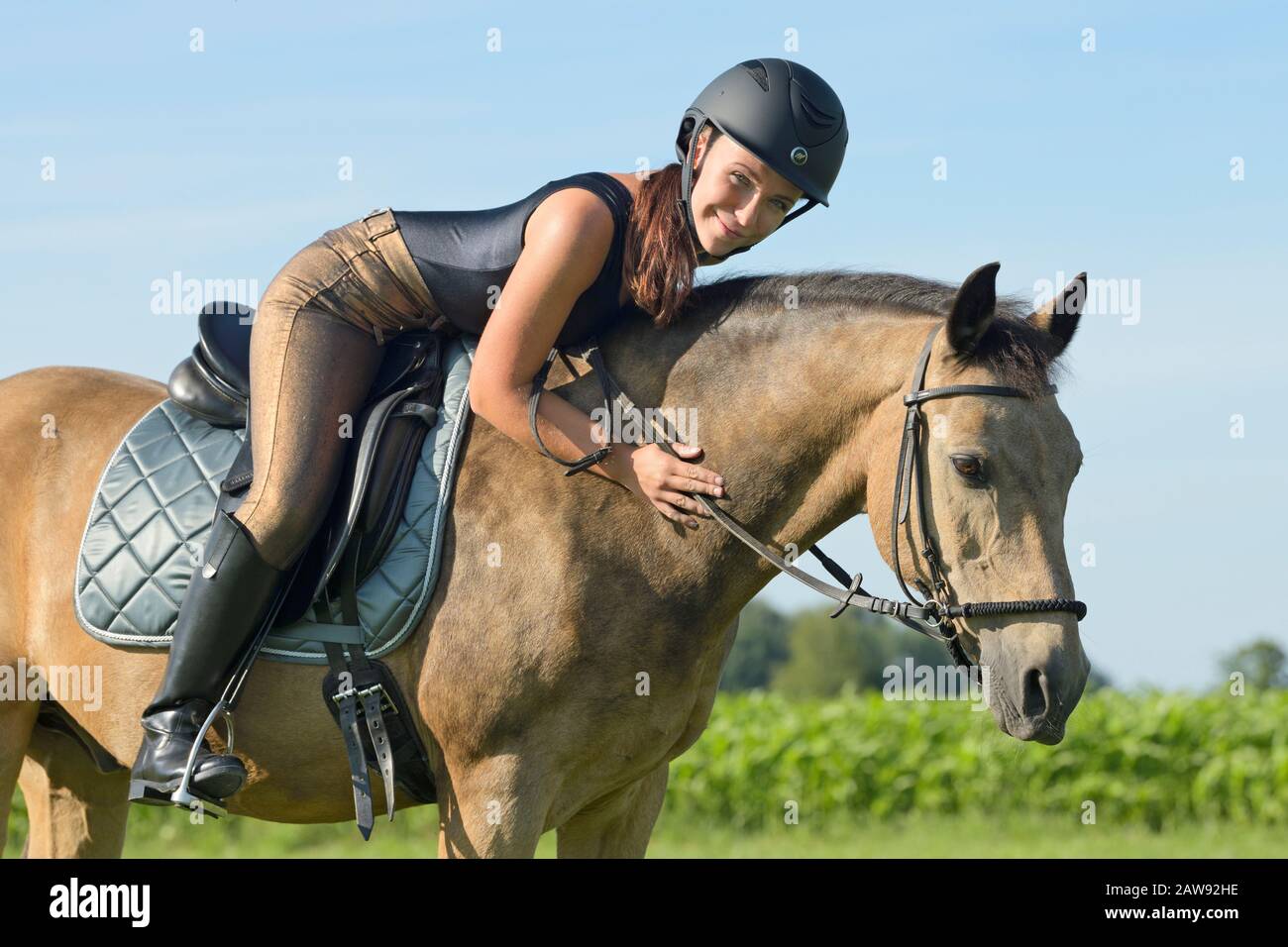 Young rider wearing a leotard and shiny riding breeches on back of a ...