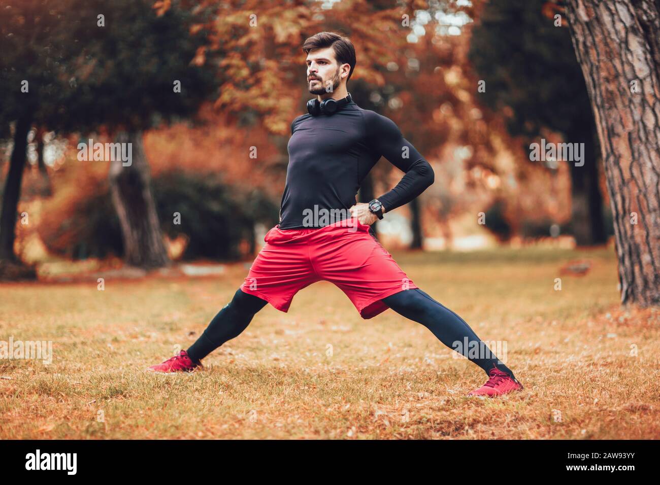Sporty young man stretching muscles hi-res stock photography and images ...