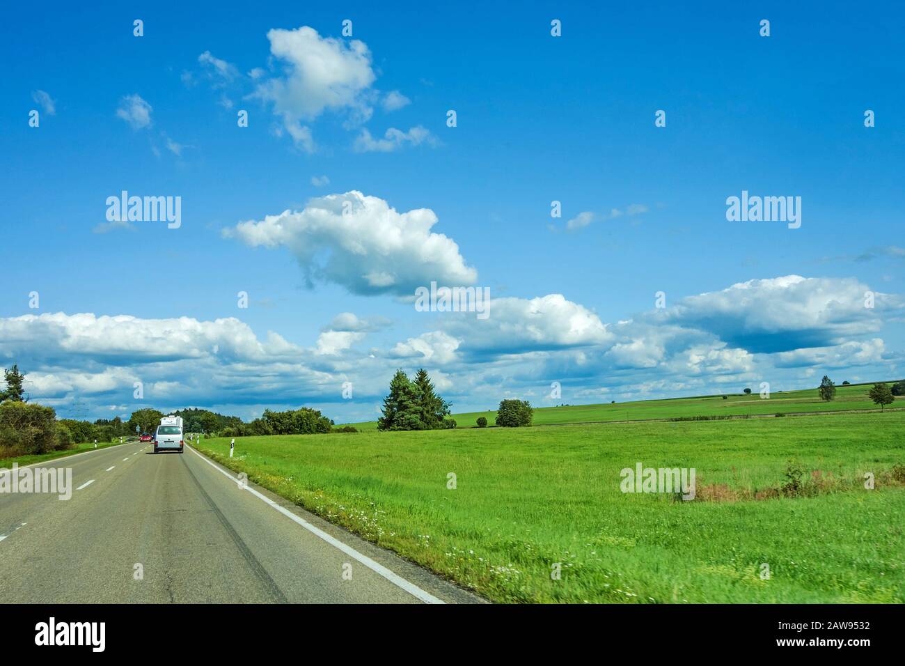 road alongside green rural landscape, blue sky with clouds Stock Photo ...
