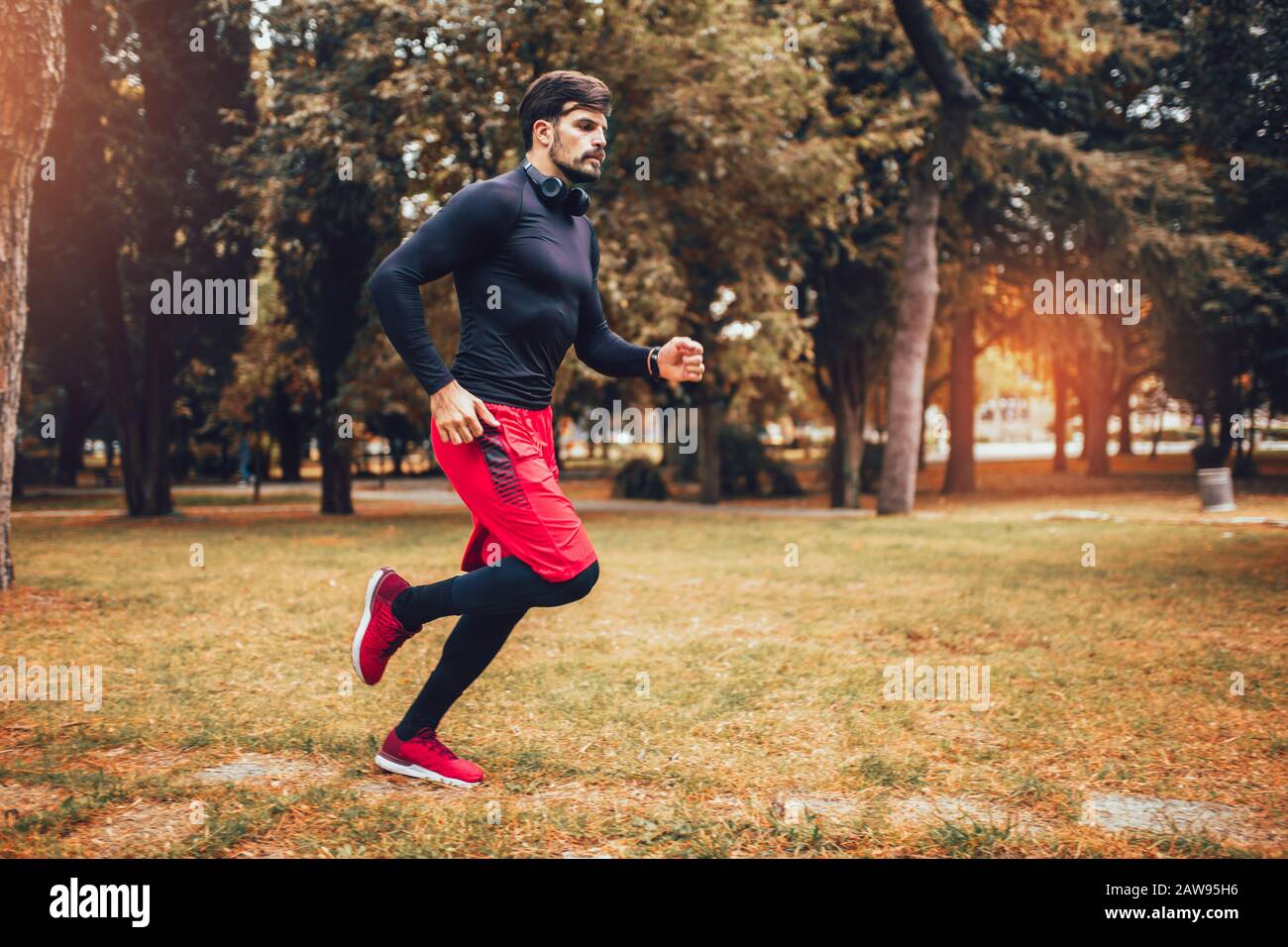 Young man running at park during morning Stock Photo - Alamy