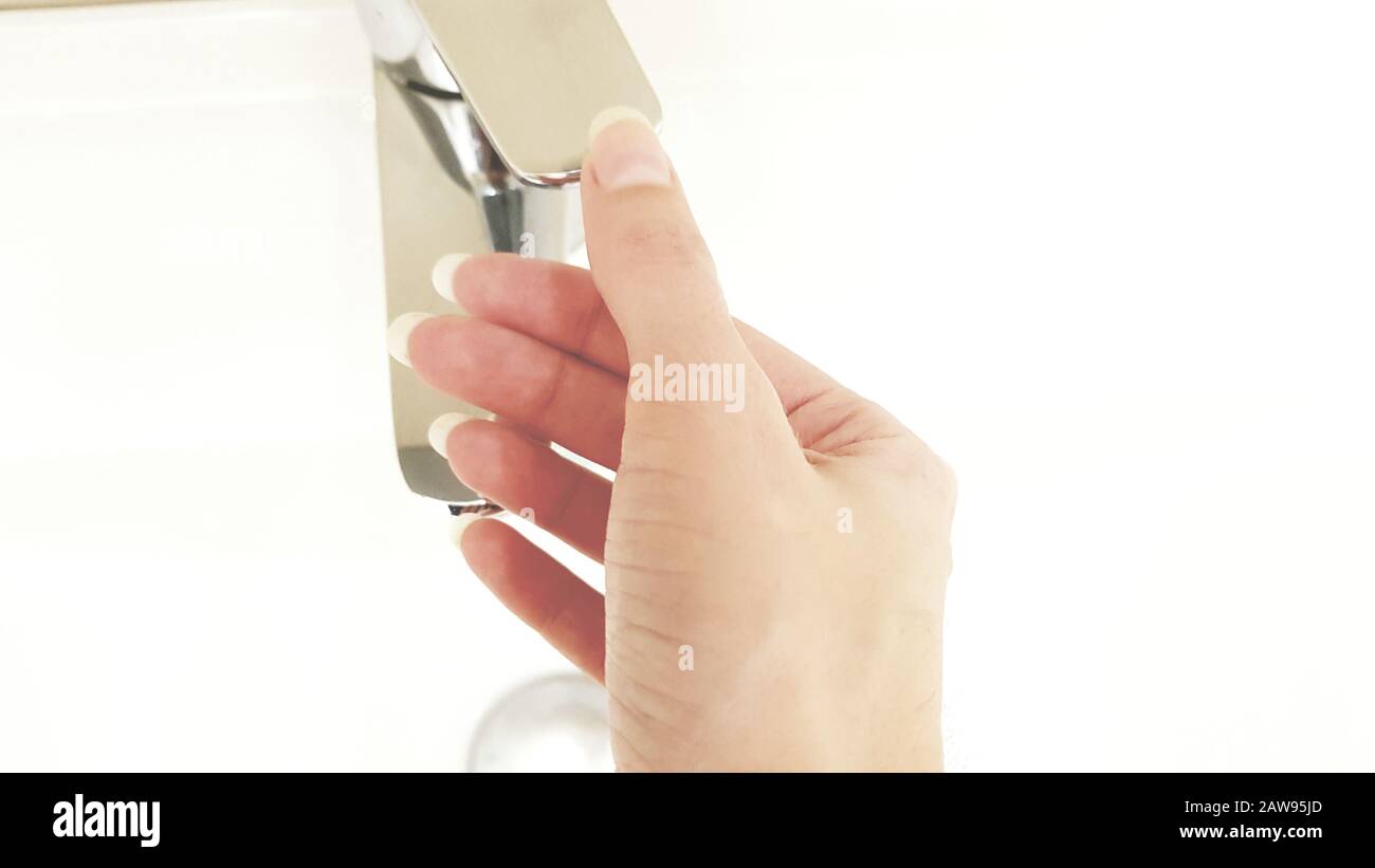 Close-up female hand uses a water tap Stock Photo - Alamy