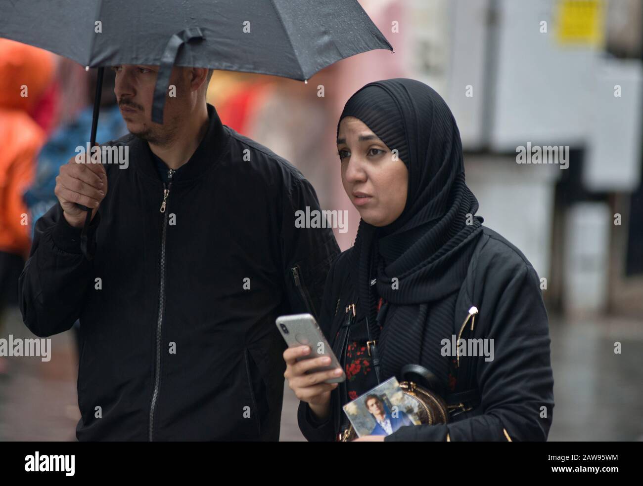 Istanbul: muslim couple walking under the rain on Istiklal avenue ...