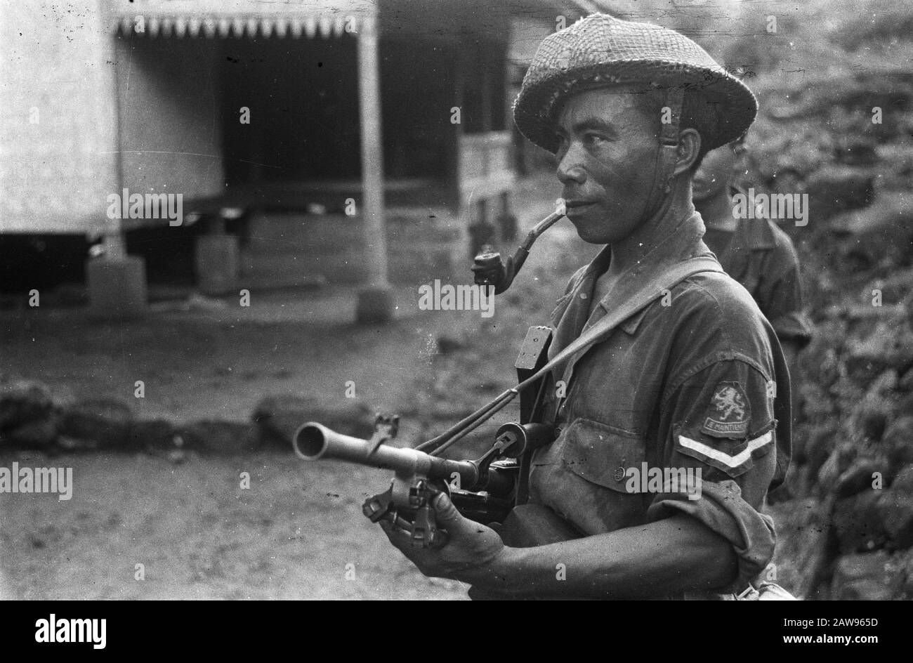 KNIL corporal with helmet and Bren gun smoking pipe Date: 01/01/1947 ...