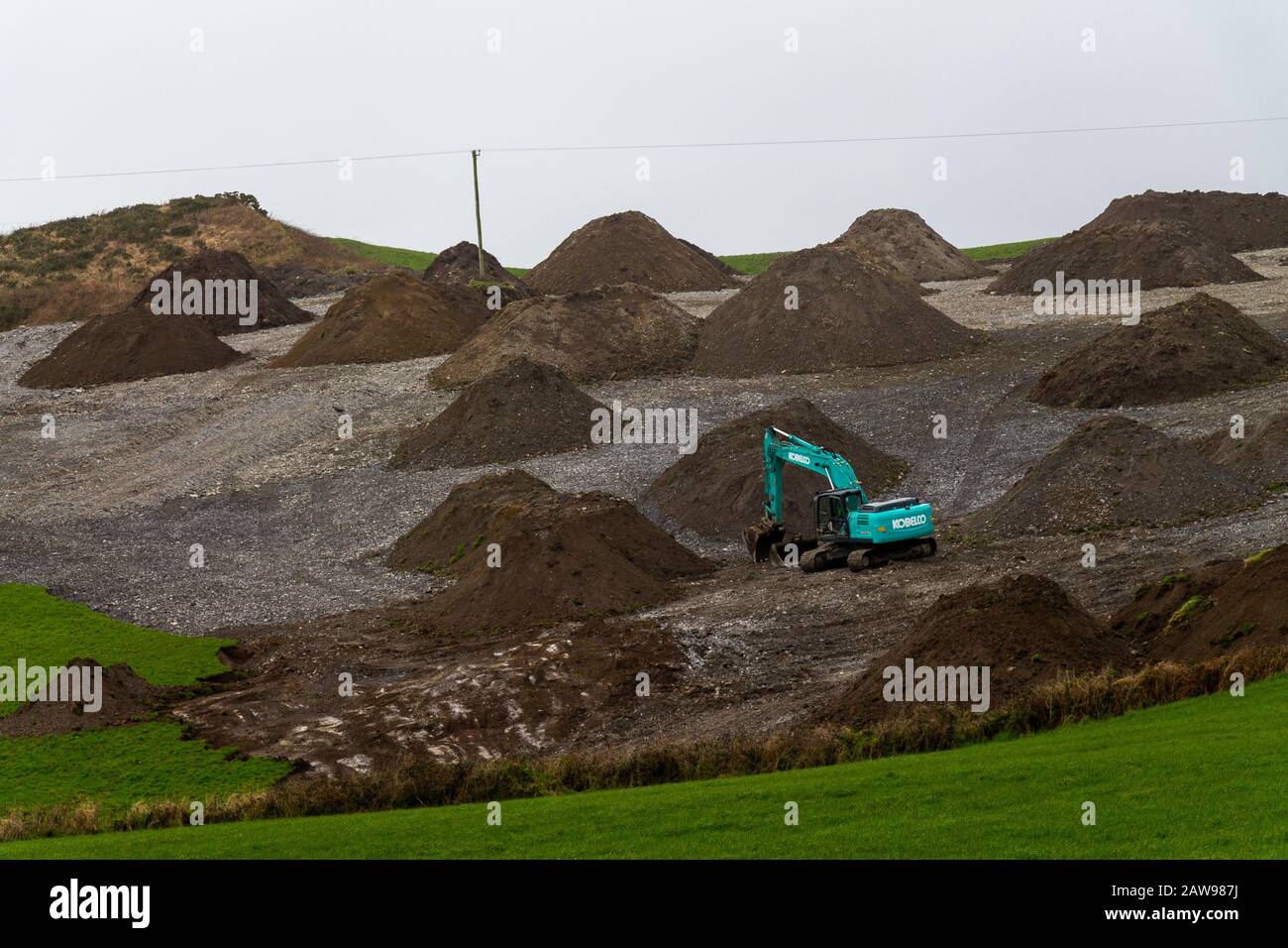 Mechanical digger clearing rocks from a field in Ireland Stock Photo ...