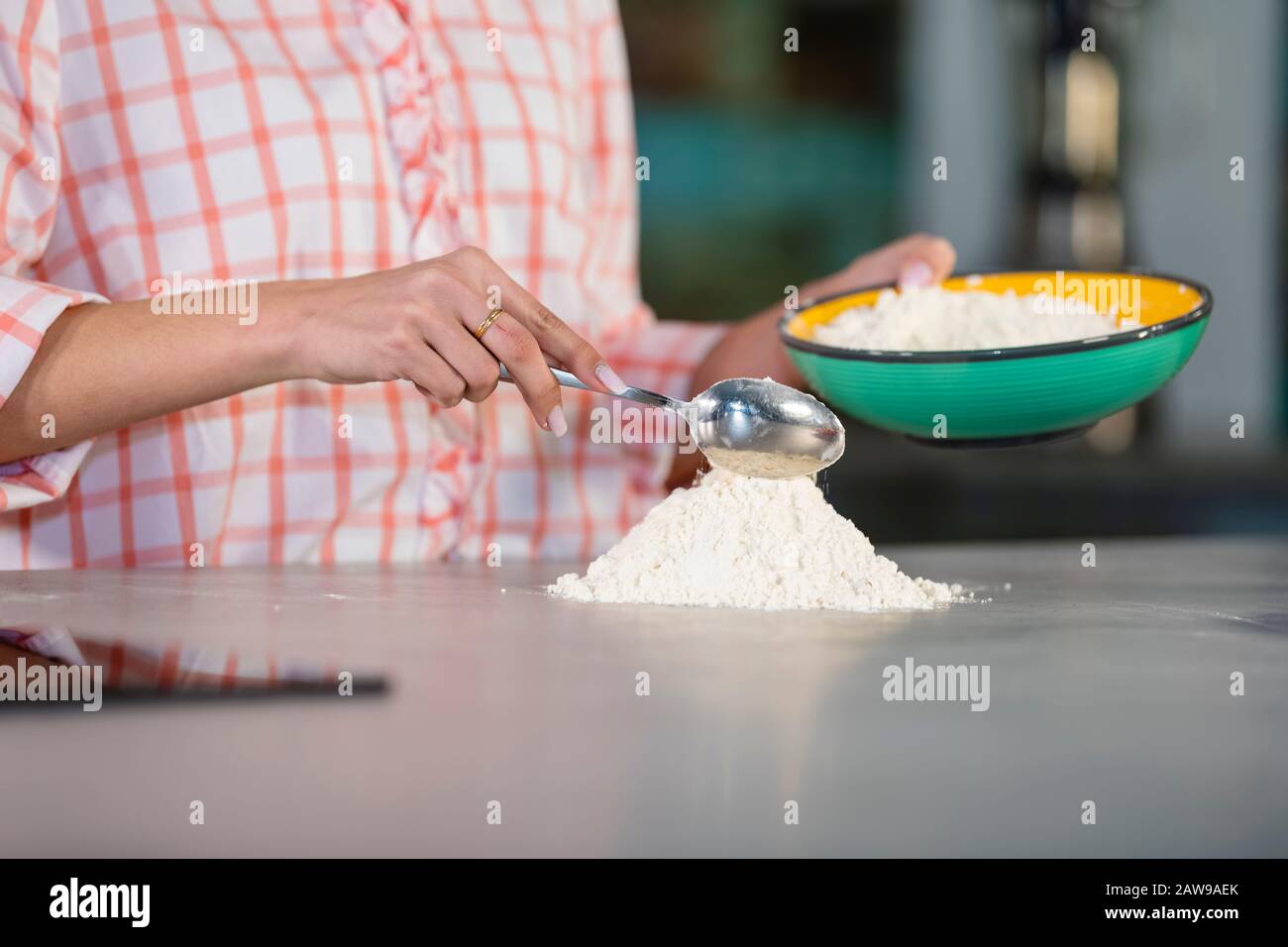 Woman adding flour to a mound on the kitchen counter Stock Photo - Alamy
