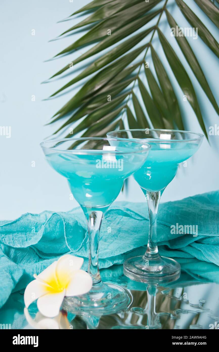 Exotic tropical Blue Curacao cocktail drink in a glasses with Plumeria ...