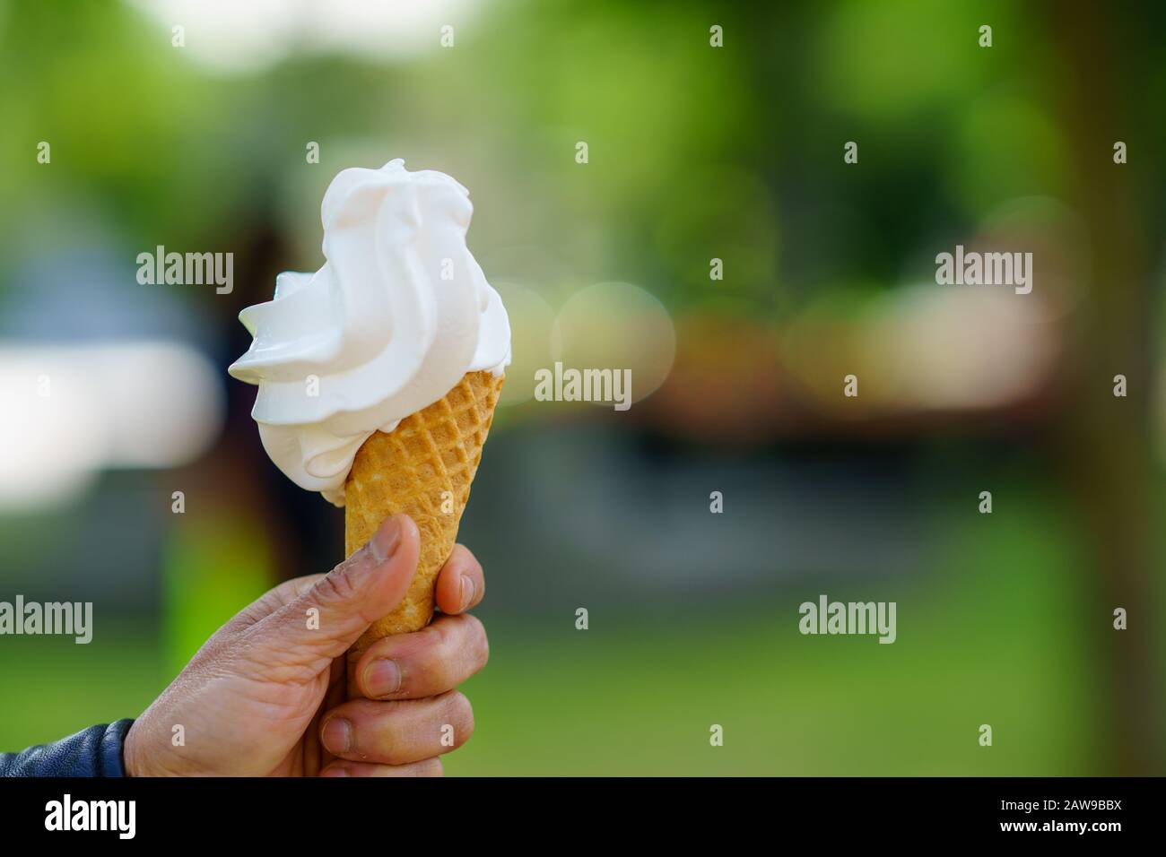 Hand holding ice cream cone. Vanilla ice cream Stock Photo - Alamy