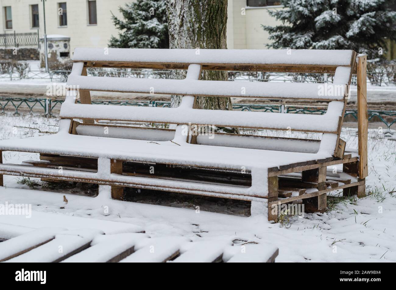Side view of an empty bench with snow. Cold winter day with flying ...
