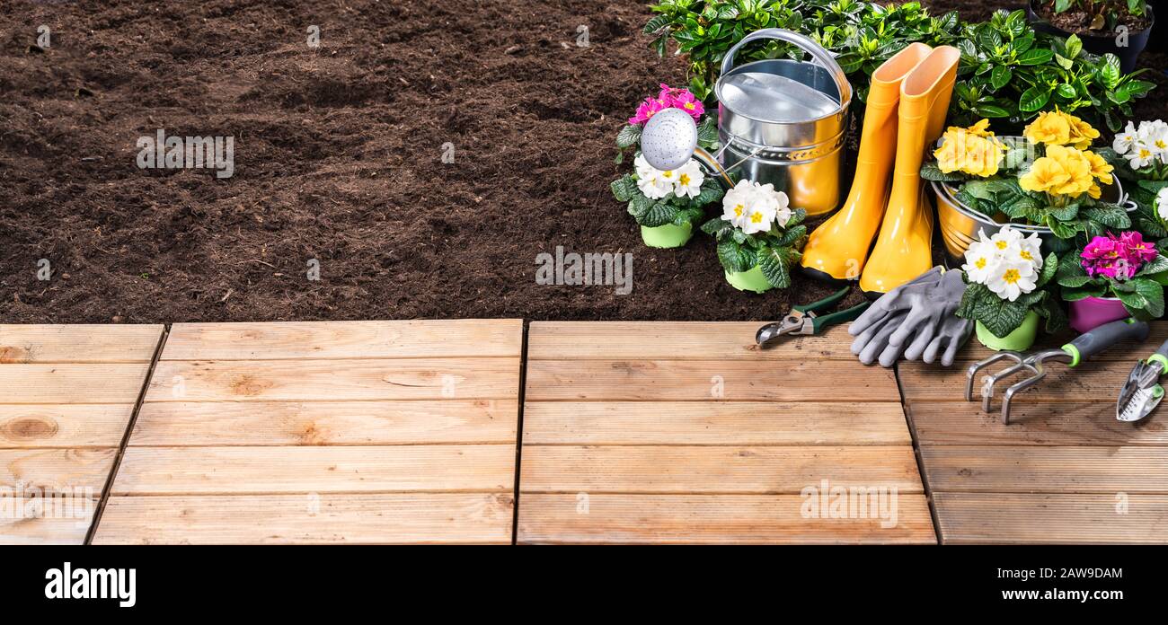 Gardening Tools Set And Flowers In Sunny Garden Stock Photo - Alamy