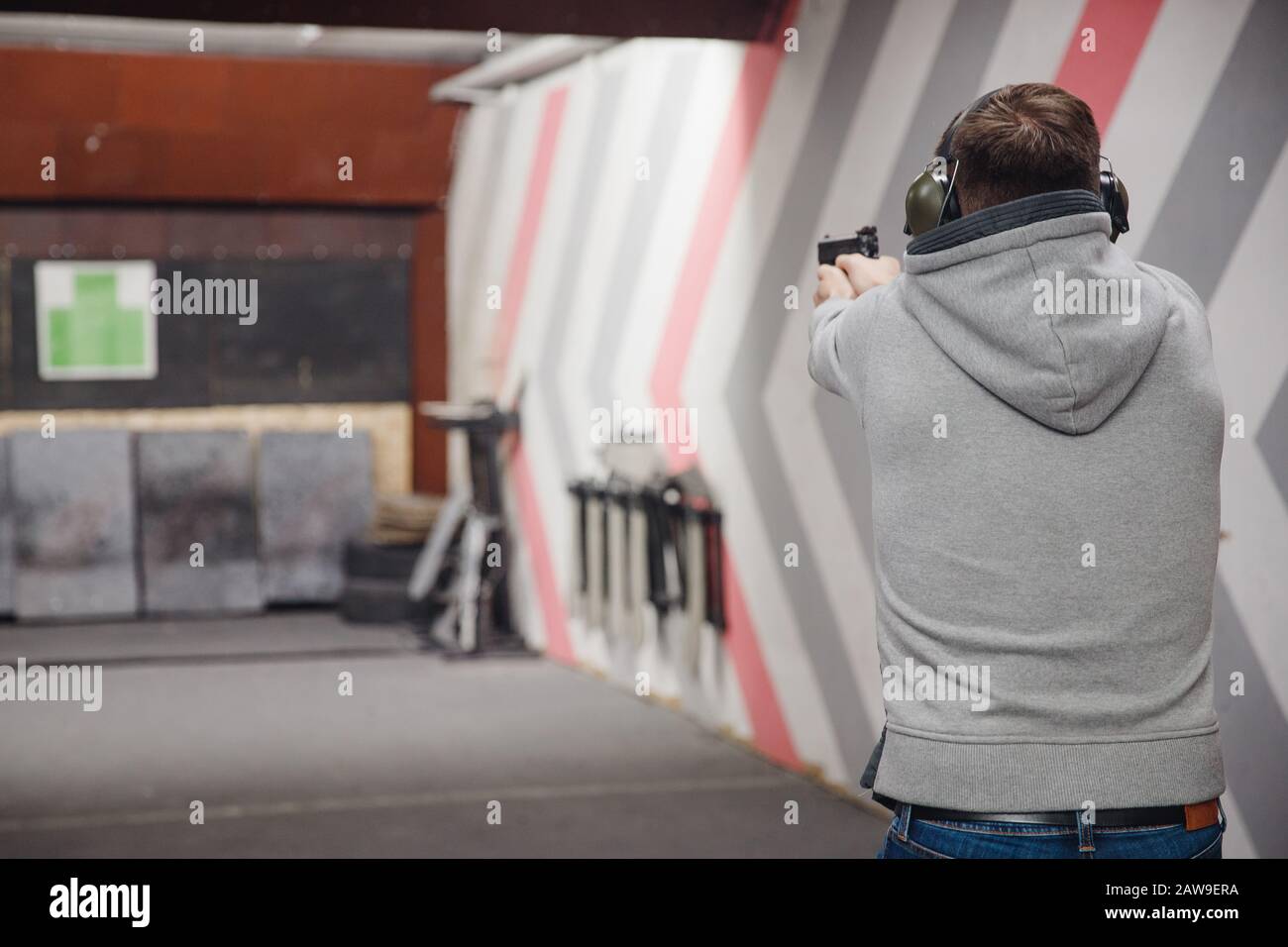 Man directs firearm gun pistol at target firing range or shooting range ...
