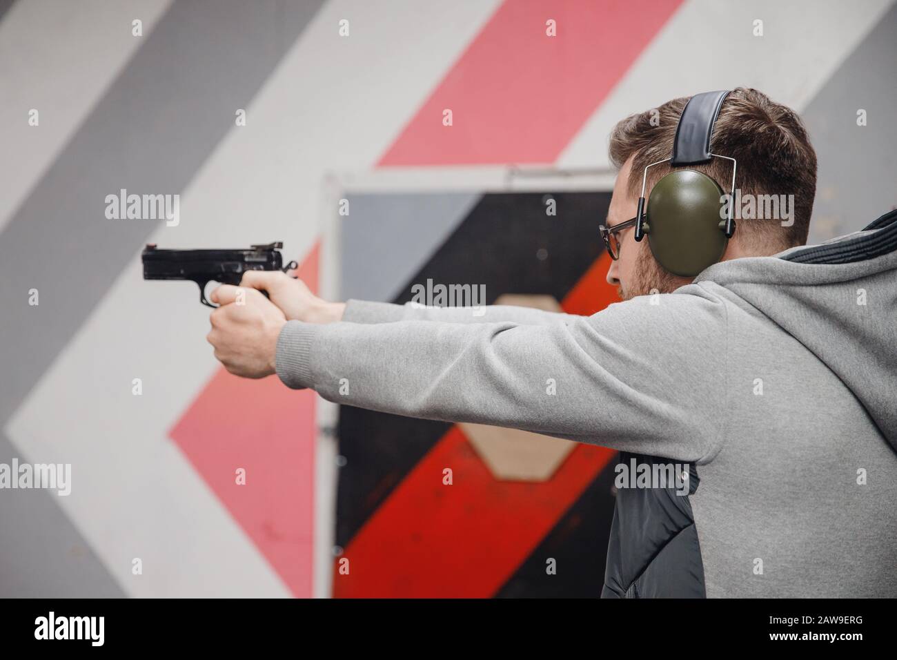 Man directs firearm gun pistol at target firing range or shooting range ...