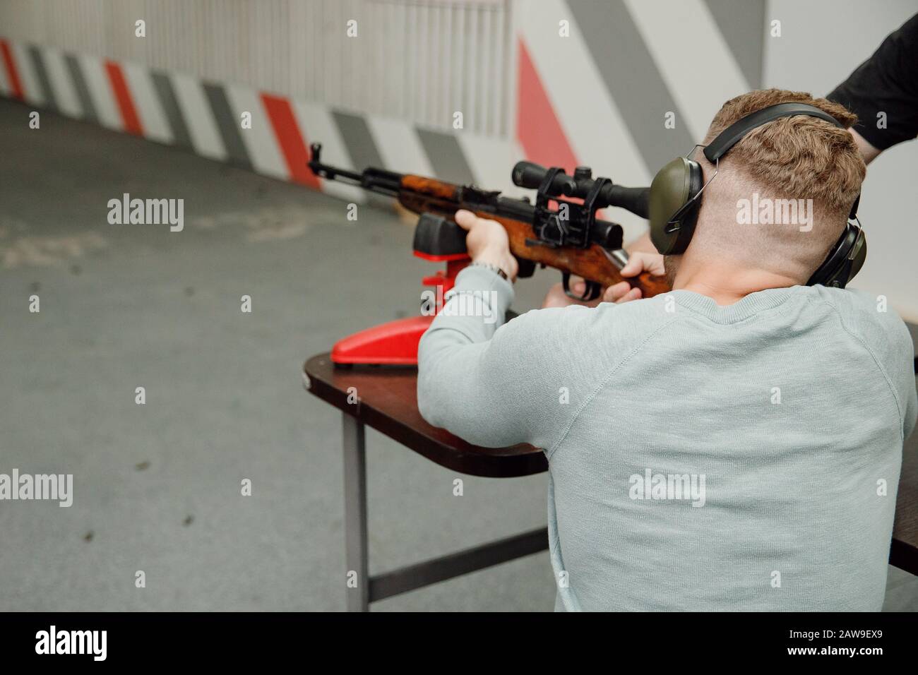 Shooting training. Man shoots from aim gun in paper target Stock Photo ...