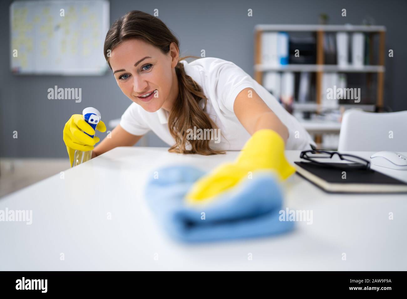 Young Worker Cleaning Desk With Rag In Office Stock Photo - Alamy