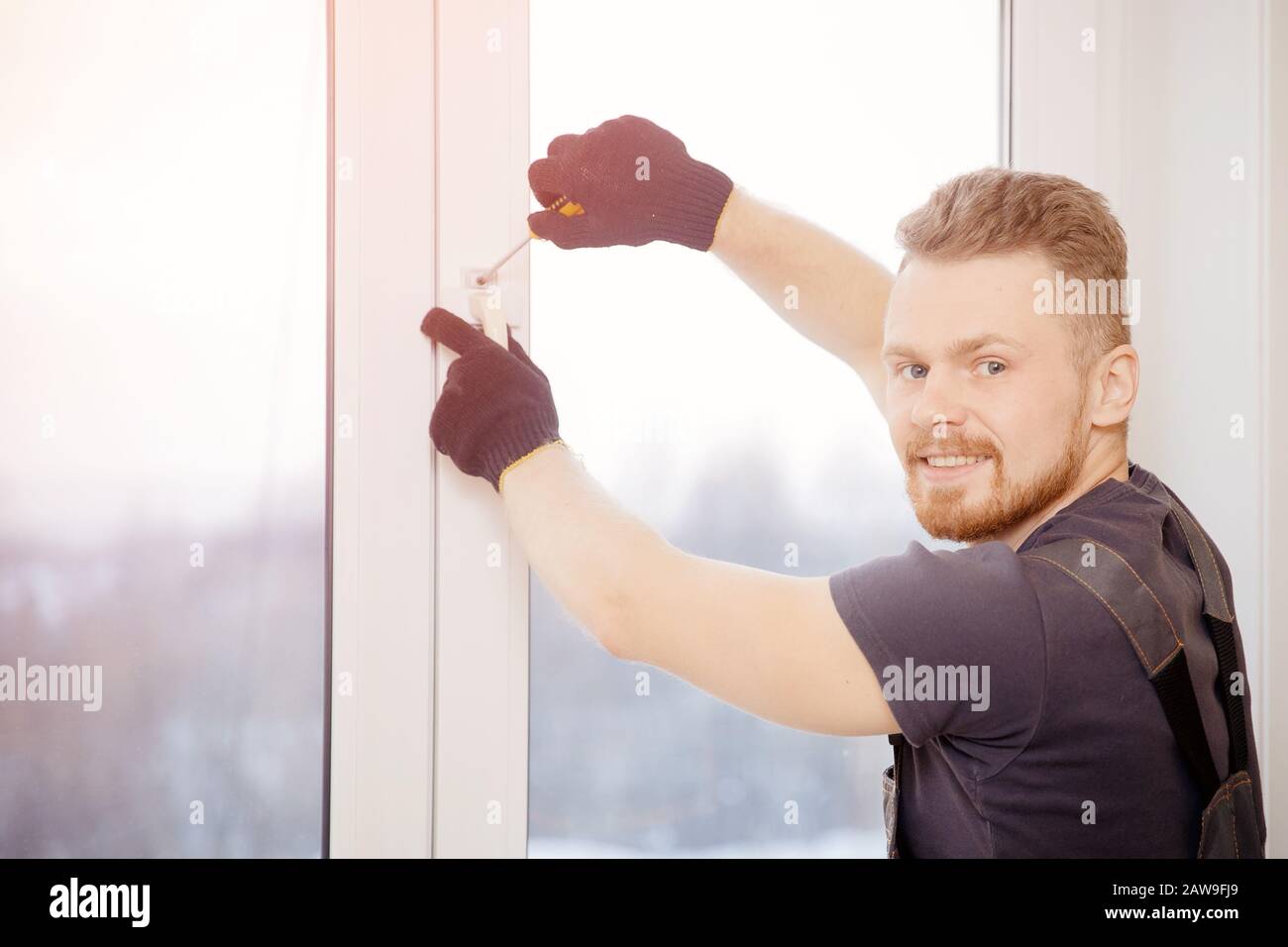 Worker man installs plastic windows and doors with double-glazed white ...