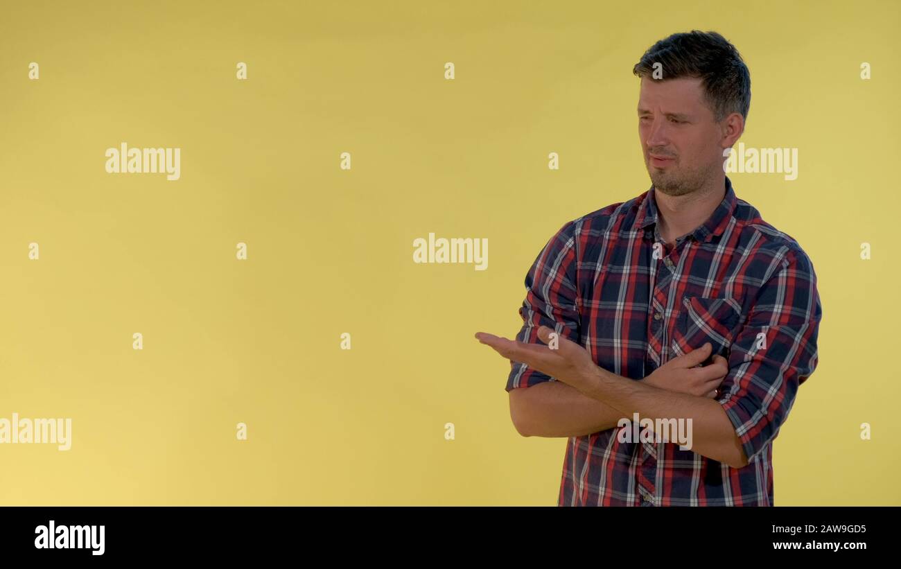 Handsome young man disliking something and giving thumbs down. There is ...