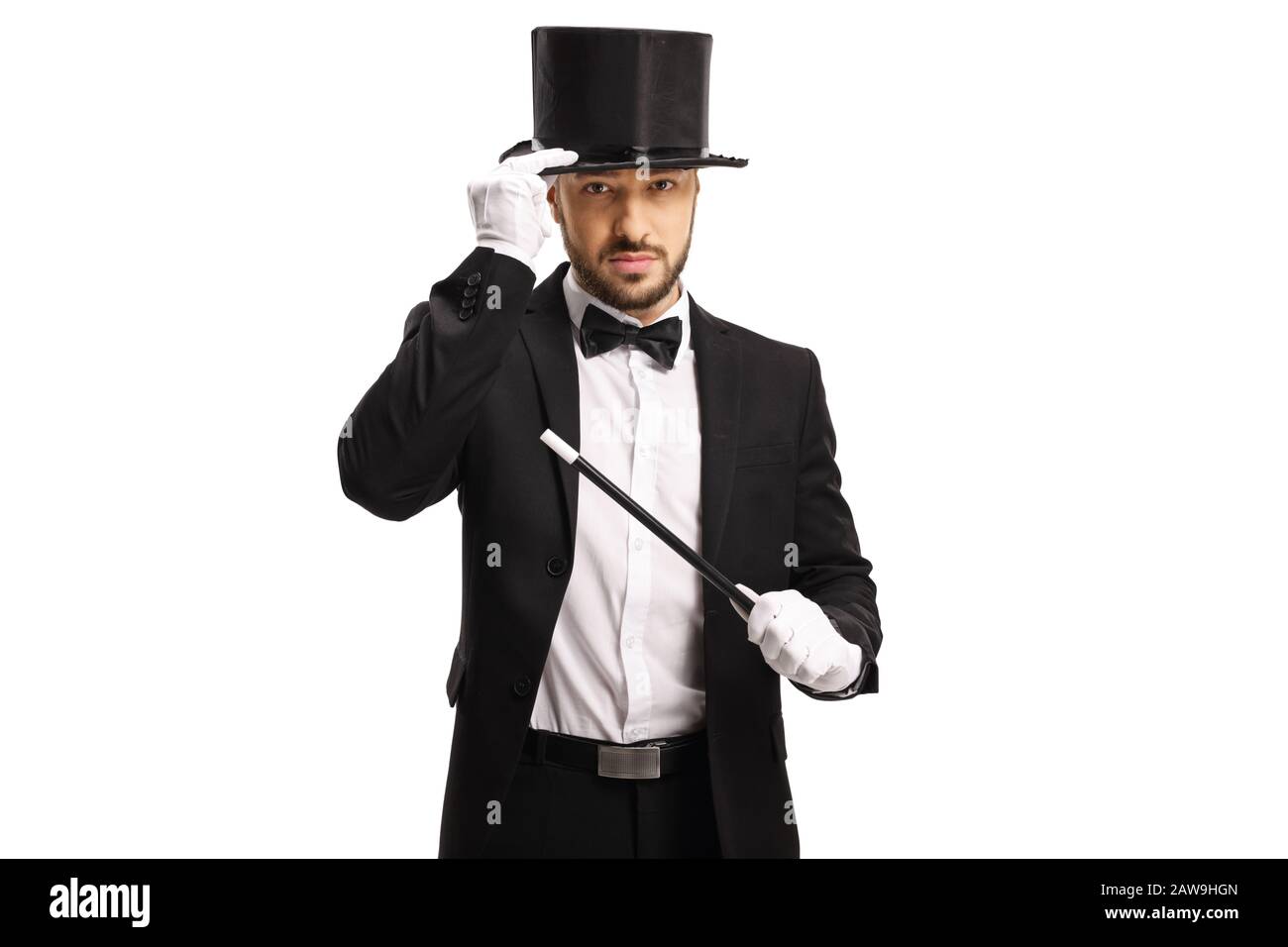 Magician with a magic wand holding his hat and looking at camera ...