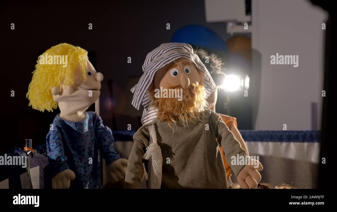 Three puppet dolls hiding under the scenes during the performance in ...