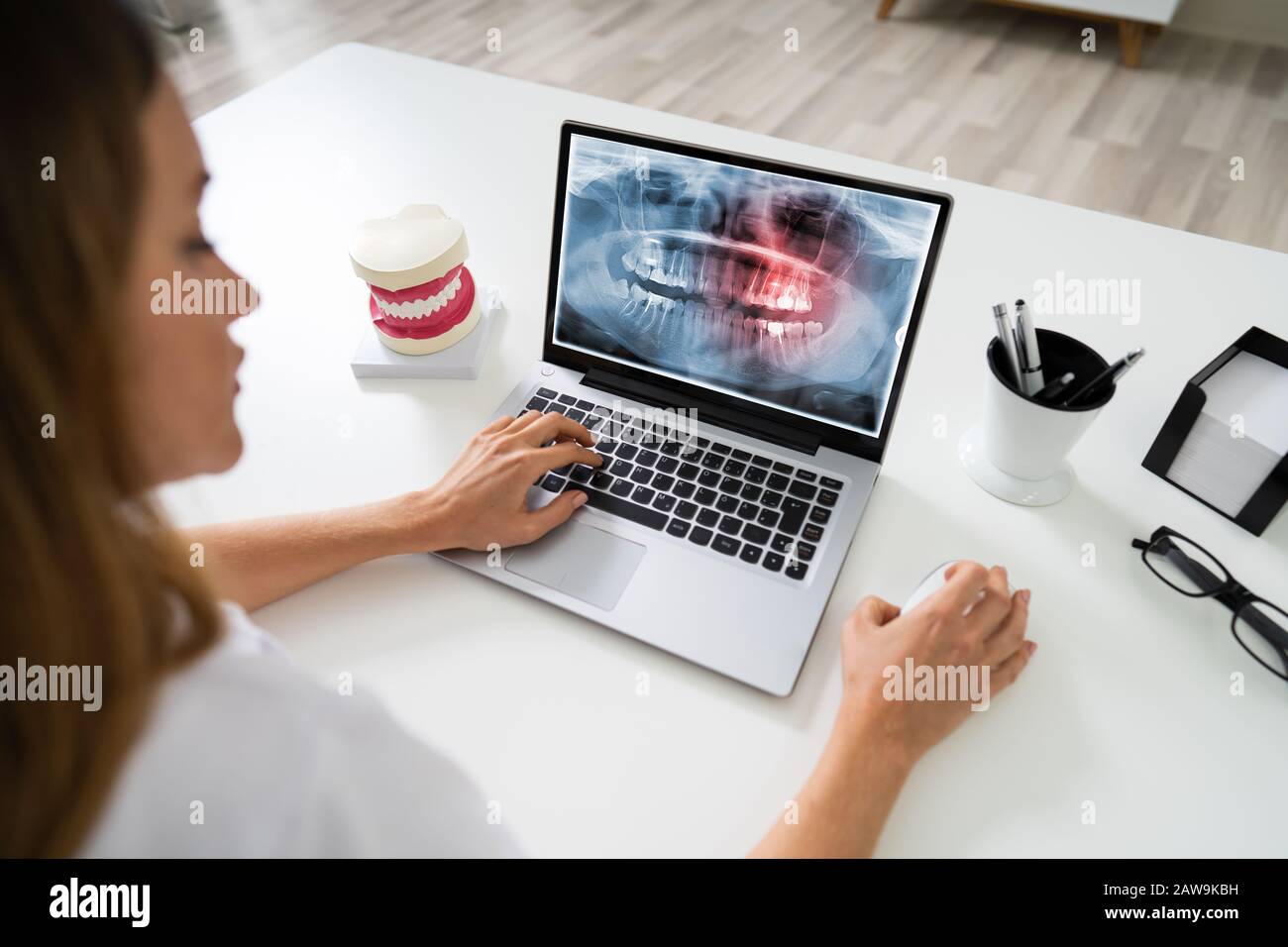 Young African Dentist Looking At Teeth X-ray On Computer At Desk Stock ...