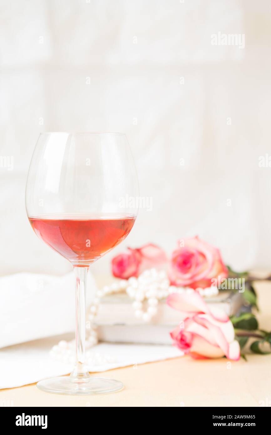 Glass of rose with vintage books and pearls. Lightweight background ...