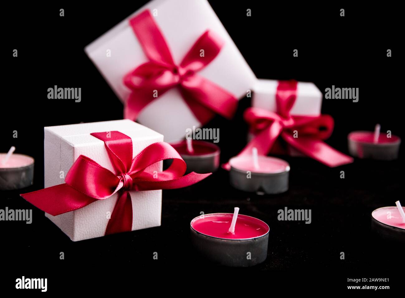 Gifts with pink ribbon and candles on the black background Stock Photo ...