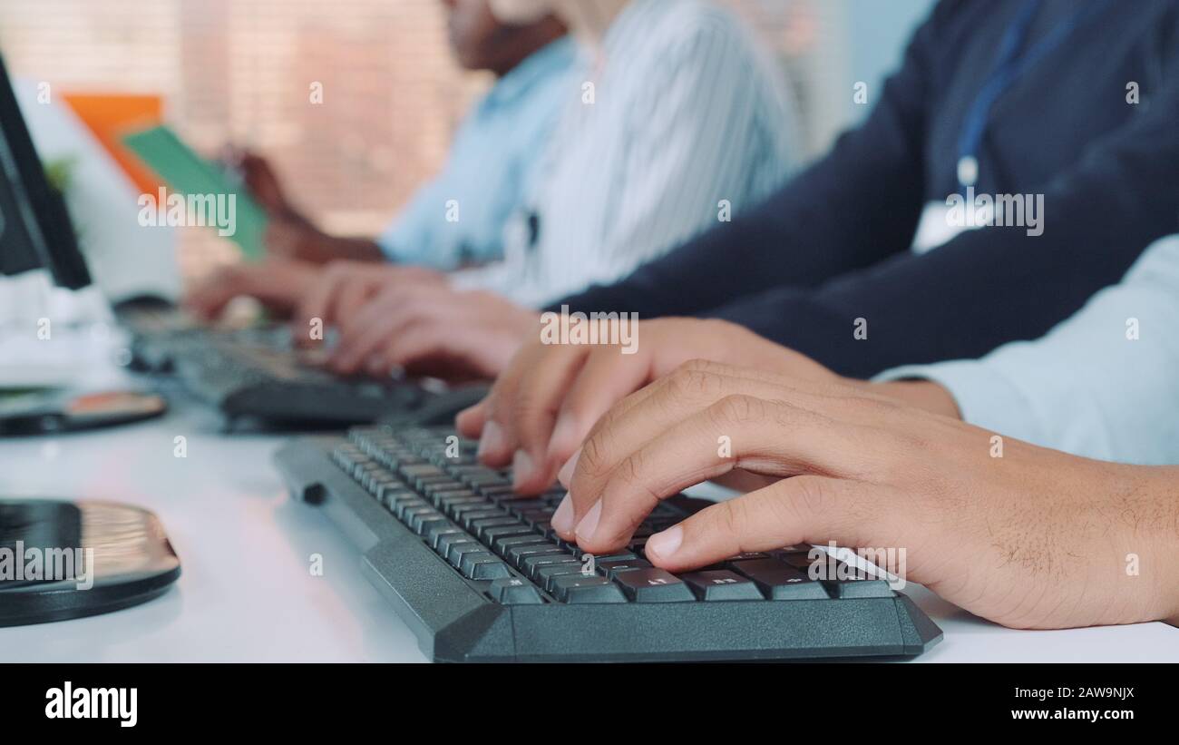 Close-up shot of operators hands typing on keyboard in modern office ...