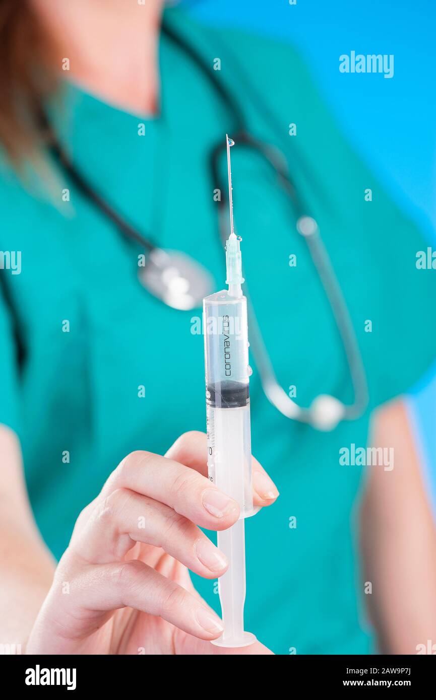 Coronavirus. A female doctor with a green unformm and a holding Syringe ...