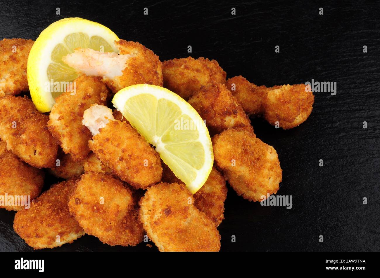 Crispy breadcrumb covered fried scampi on a slate background Stock ...