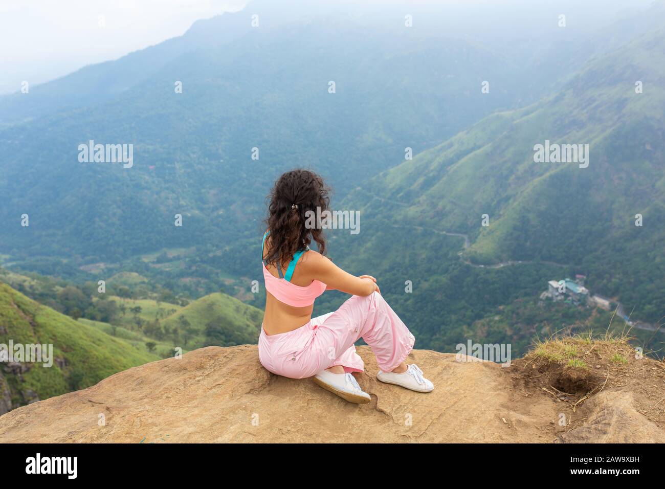 Girl enjoys a mountain view while standing on a cliff Stock Photo - Alamy