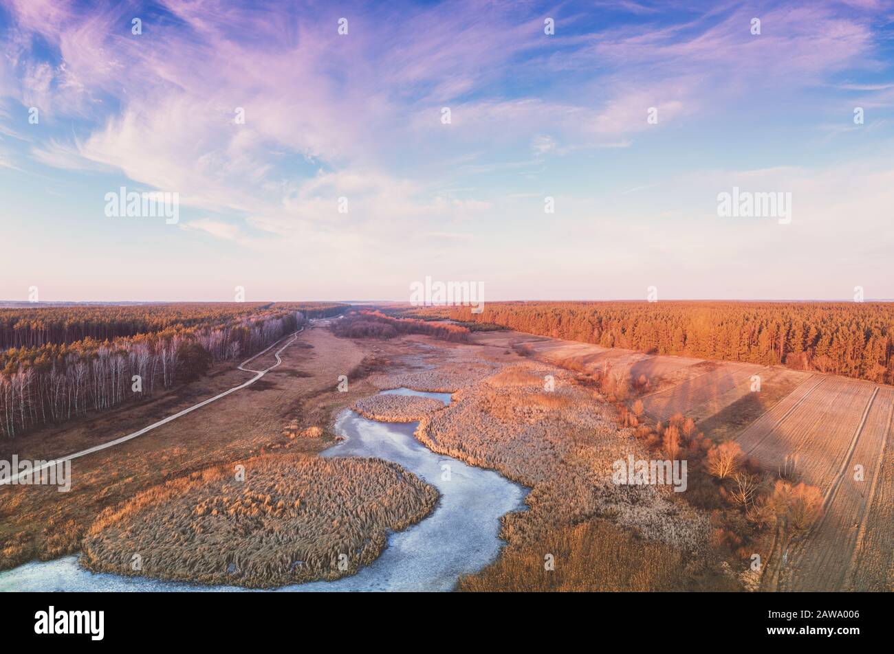 Aerial view of the countryside and frozen brook in the evening at ...