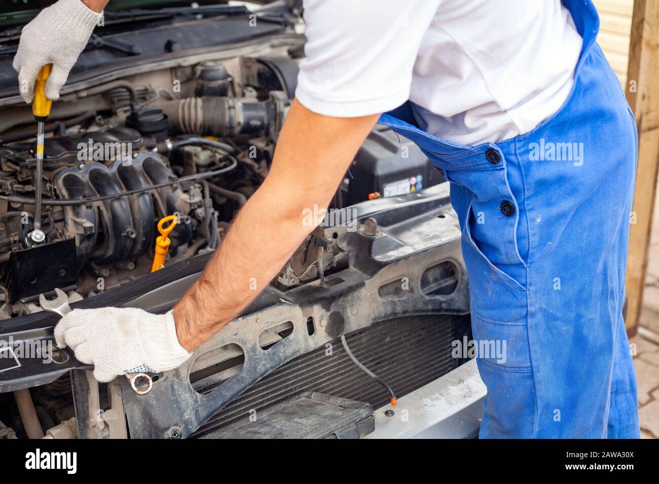 mechanic men with wrench repairing car engine at workshop - auto ...