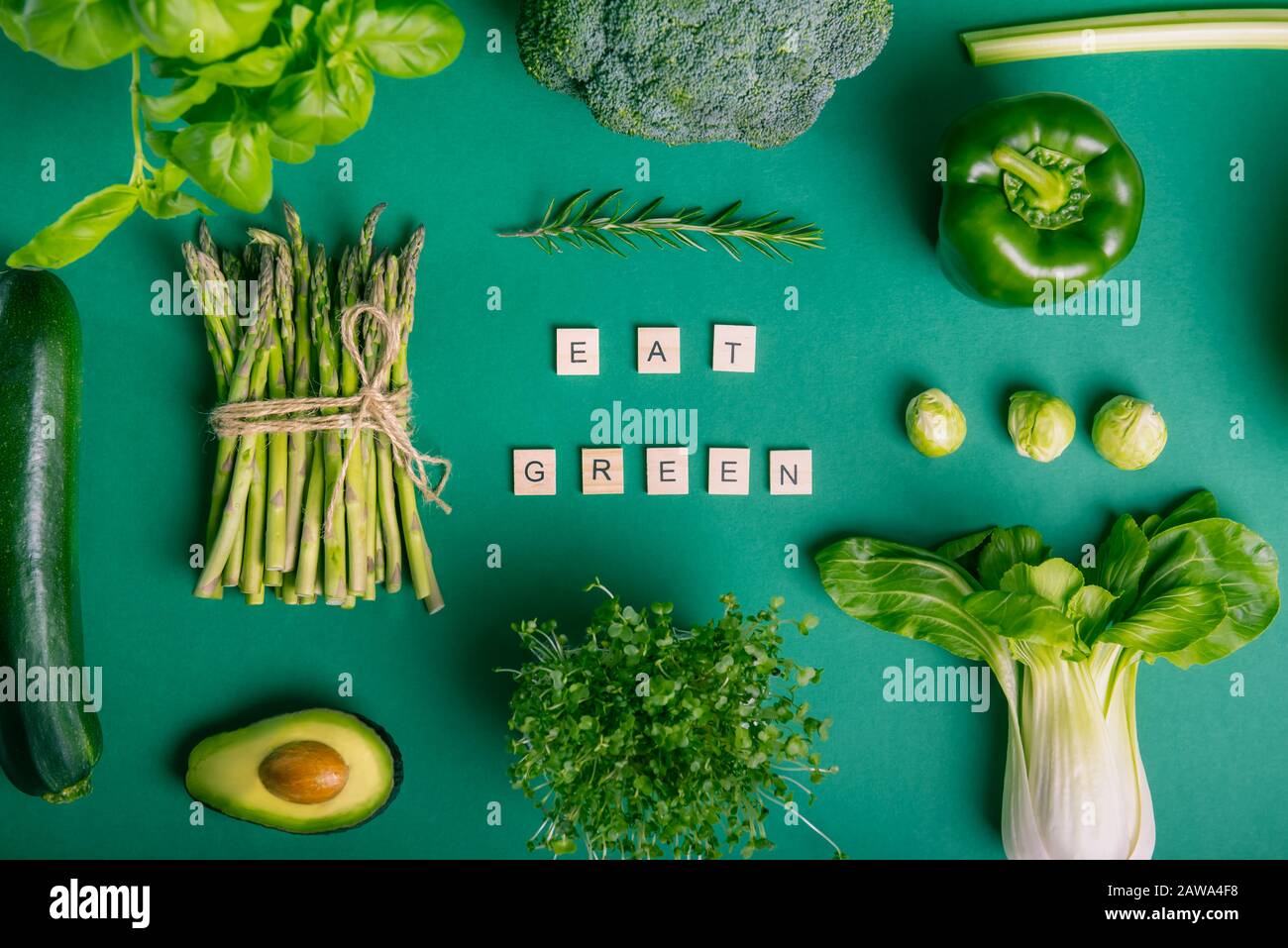 Top view set of healthy raw vegetables on the green background with Eat ...