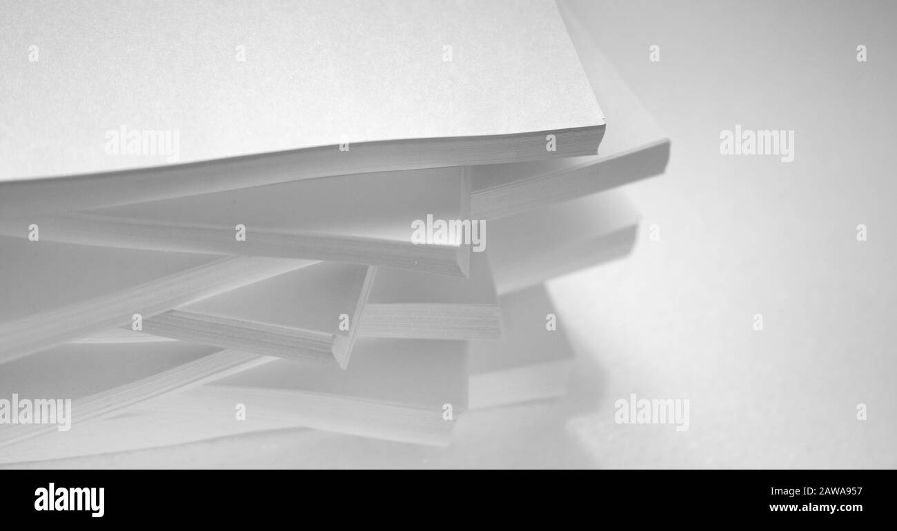 Several stacks of white paper on a white background Stock Photo - Alamy