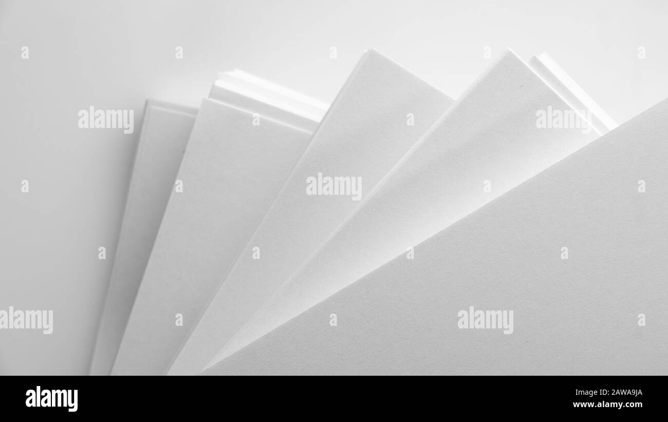 Several stacks of white paper on a white background Stock Photo - Alamy