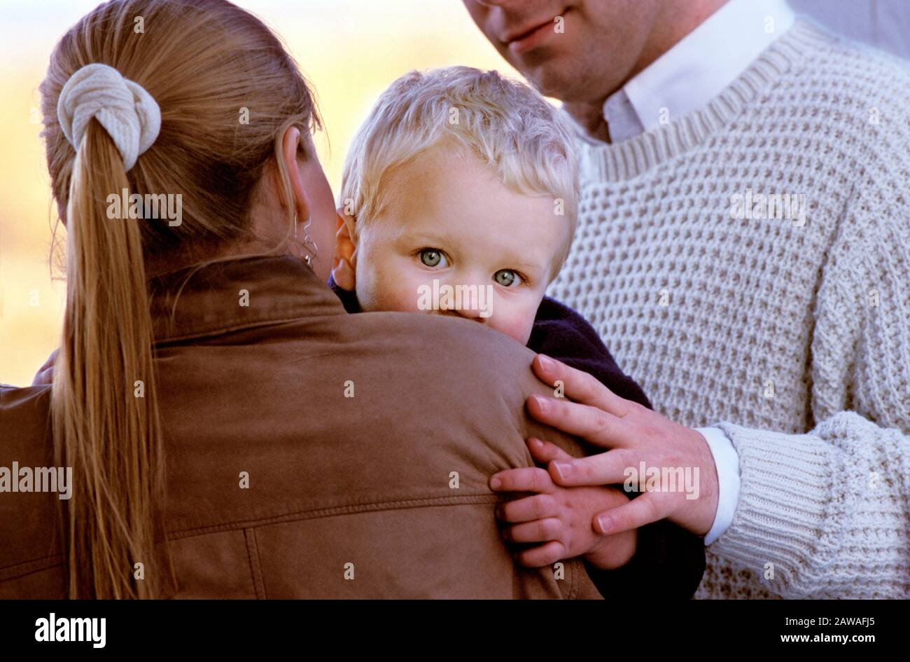 Parents holding a frightened child Stock Photo - Alamy